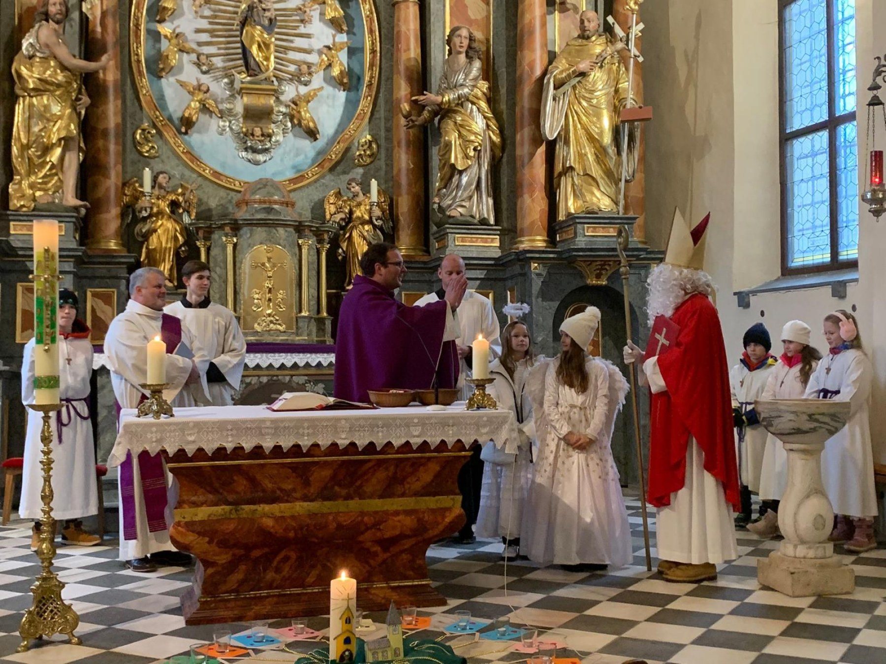 Besuch vom Nikolaus in der Kirche und der Brauchtumsgruppe am Kirchplatz